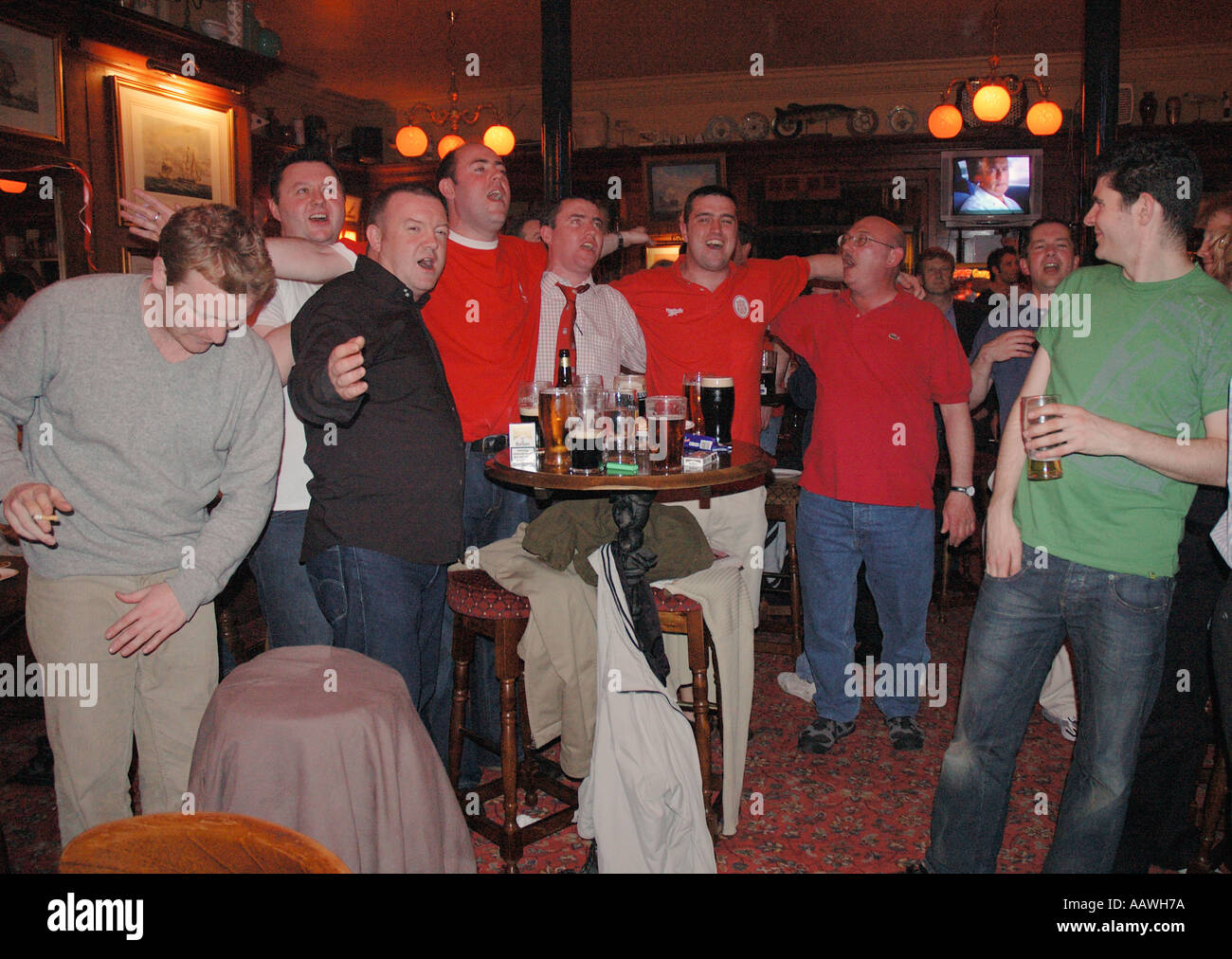 Group of Liverpool supporters watching football match in local pub ...