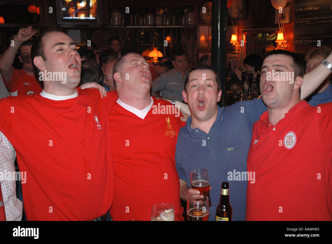 Group of Liverpool supporters watching football match in local pub ...