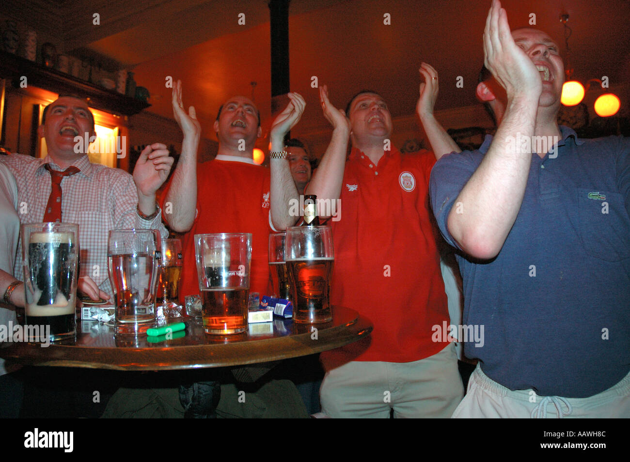 Group of Liverpool supporters watching football match in local pub ...