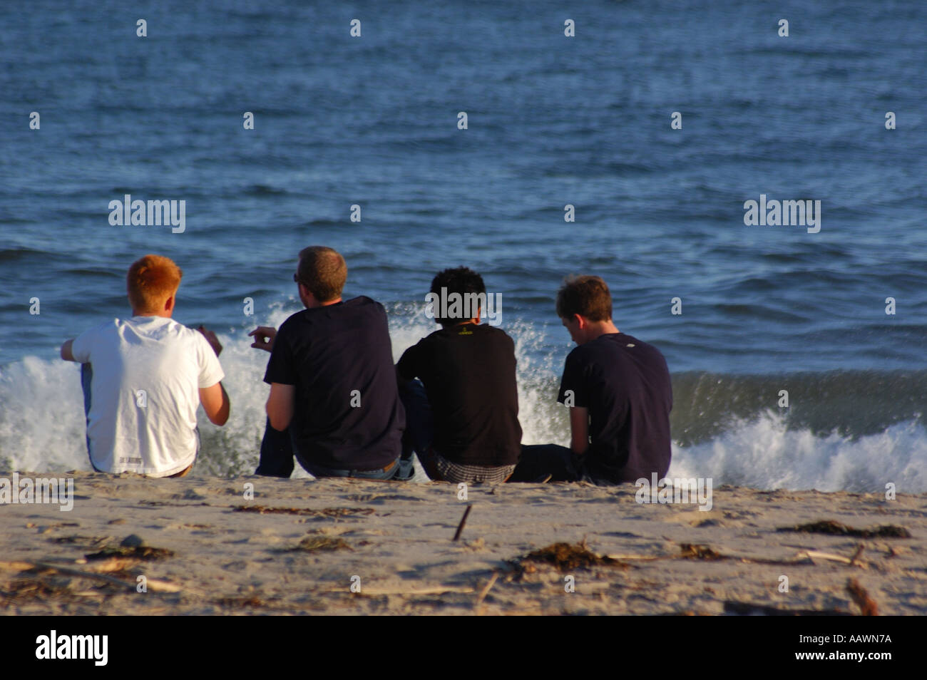Boys Sitting On Beach Stock Photo - Alamy