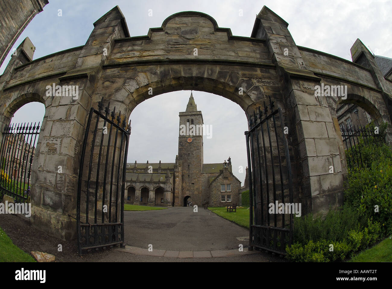 Archway with iron gate, church in the background, St. Andrews, Scotland ...