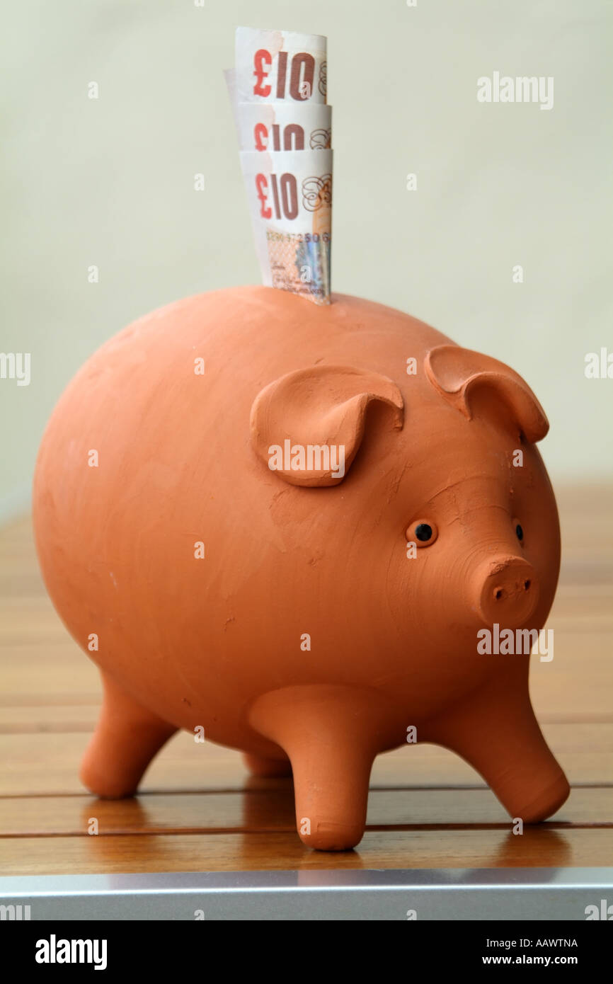 Childs Piggy bank made from clay with ten pound notes Stock Photo - Alamy