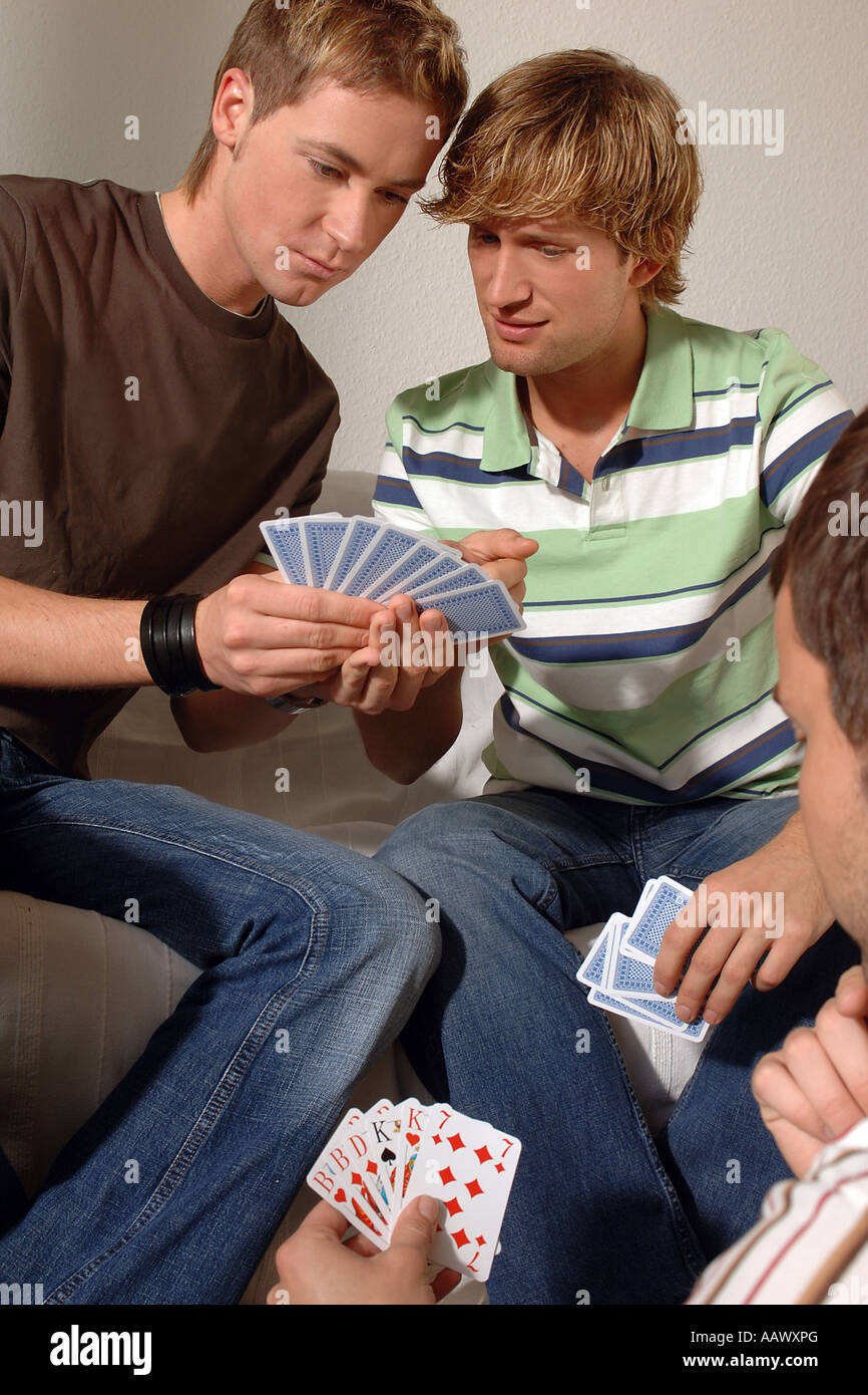 3 young men playing cards Stock Photo - Alamy