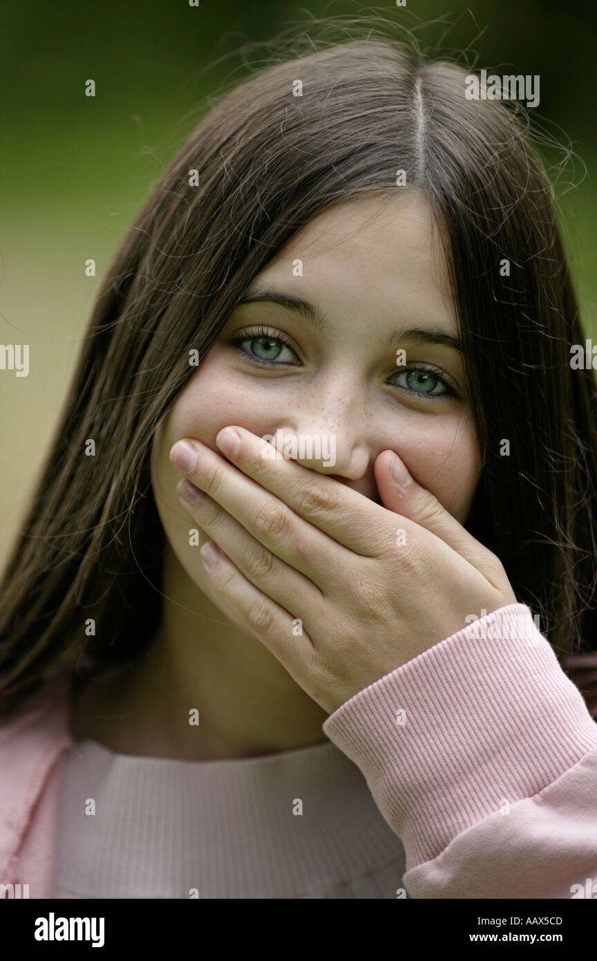 young girl laughing covering mouth with hand Stock Photo - Alamy
