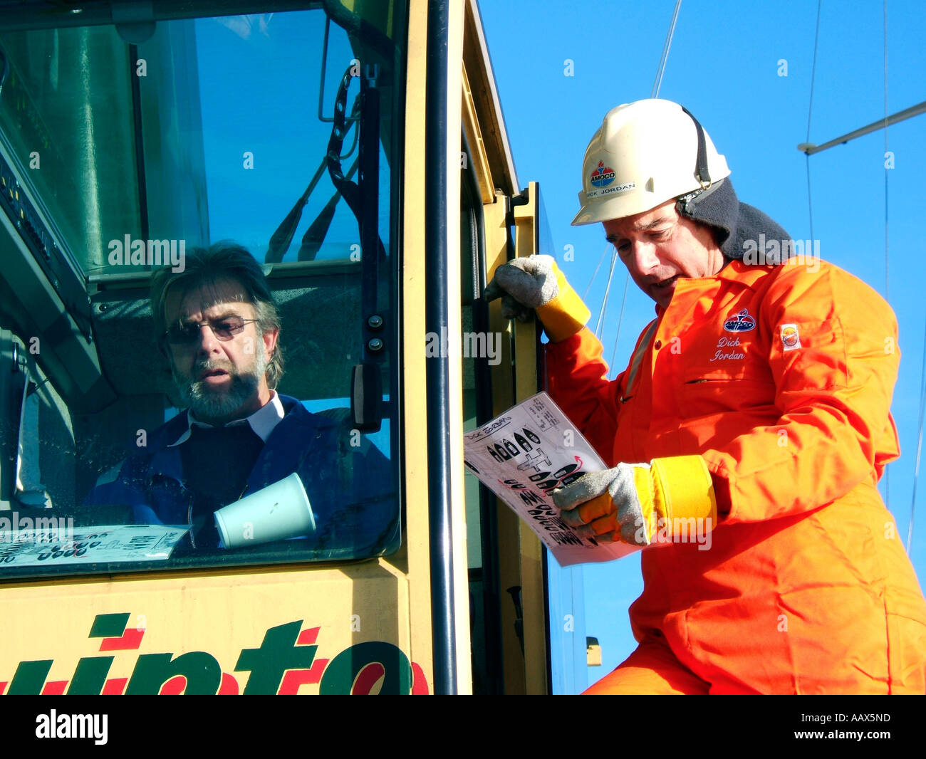 man instructing crane driver Stock Photo - Alamy
