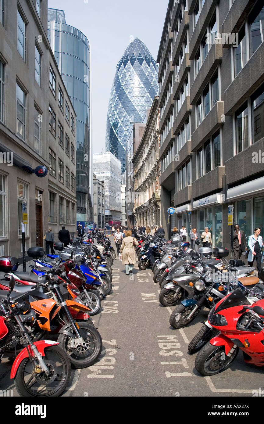 a line of motorbikes in a London street with the Gherkin building in ...
