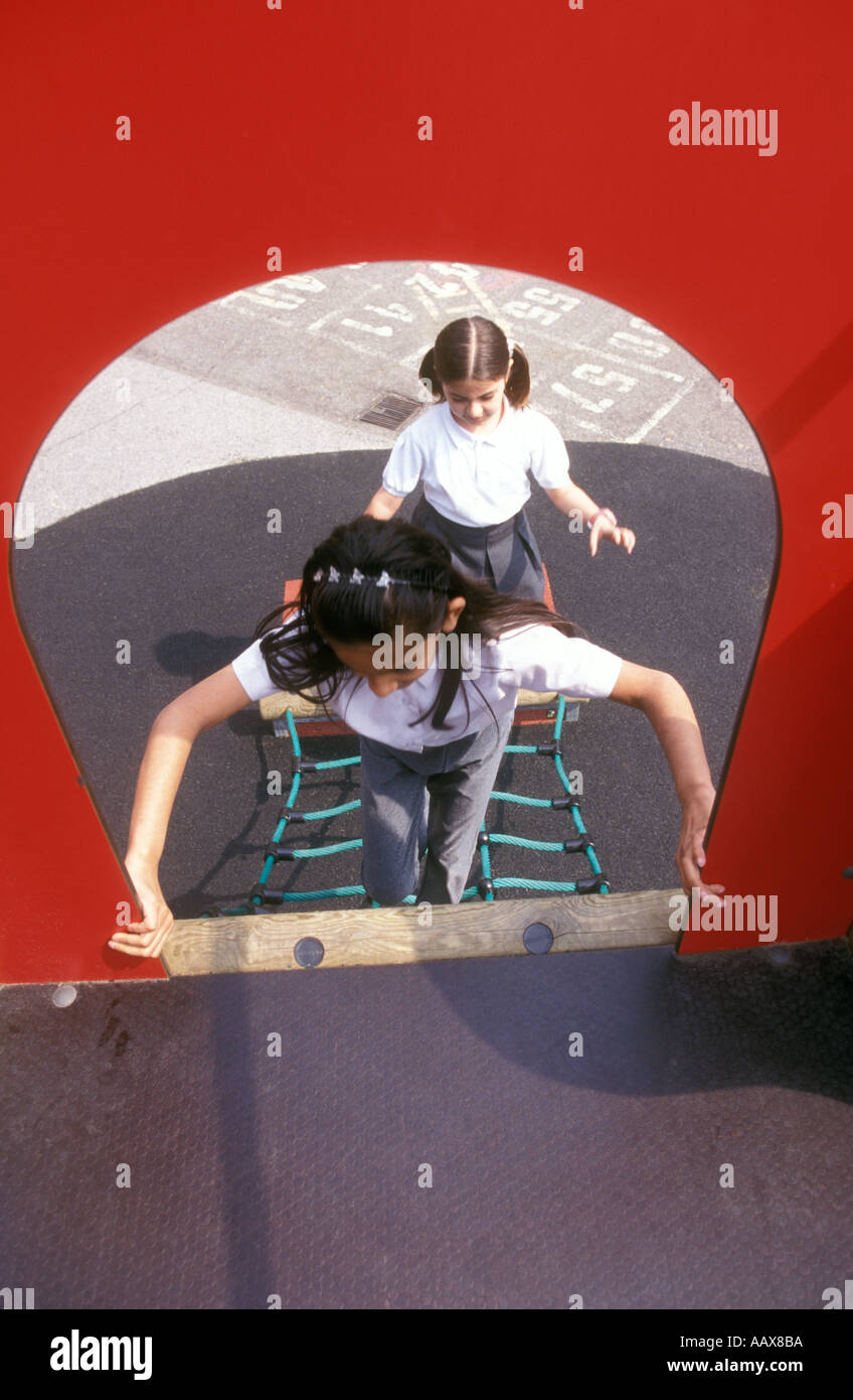 young children playing on the apparatus in the school yard at break ...