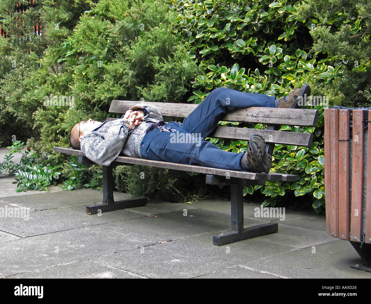 Man asleep on bench in churchyard garden Soho London UK Stock Photo - Alamy
