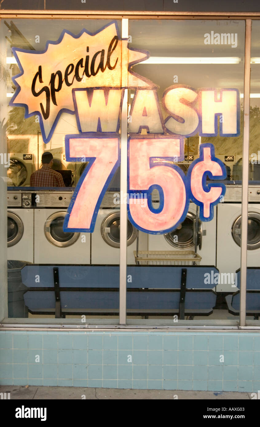 A color vertical image of the front window of a laundromat with a ...