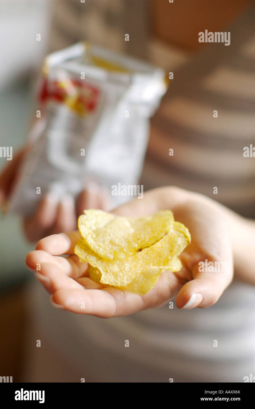 Woman holding crisps in hands Stock Photo - Alamy