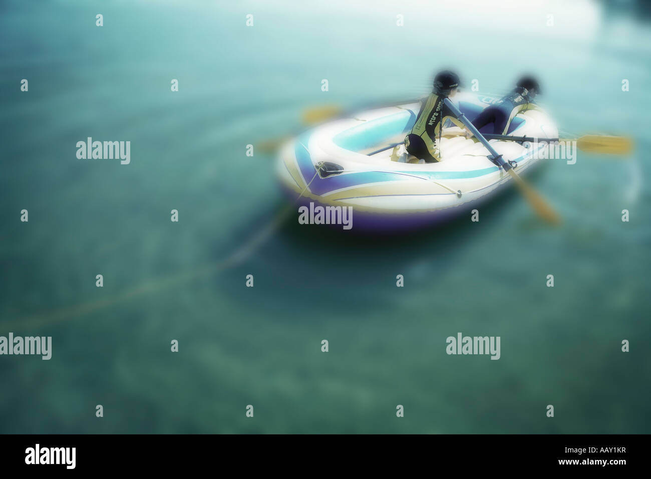 two boys playing in an inflatable boat with oars Stock Photo - Alamy
