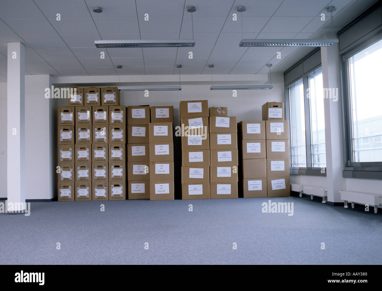 empty office space with neatly stacked cardboard boxes in background ...