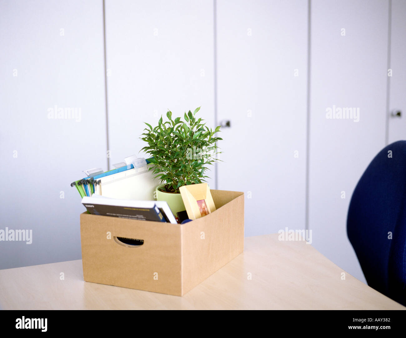 cardboard box with personal objects on empty office desk Stock Photo ...