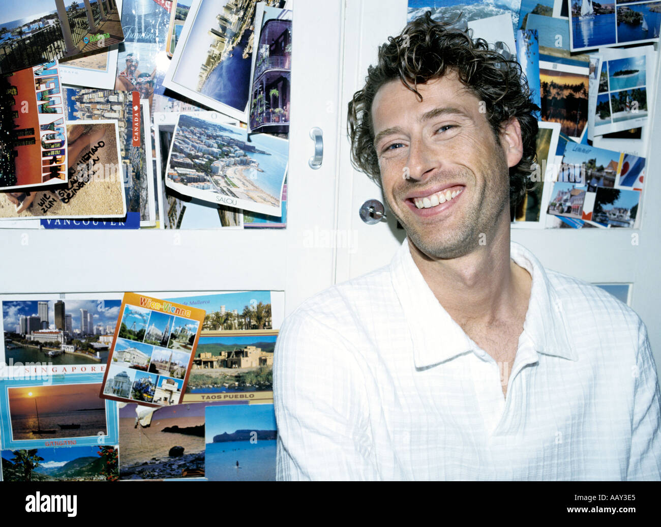 portrait of male caucasian in white shirt background full of postcards ...