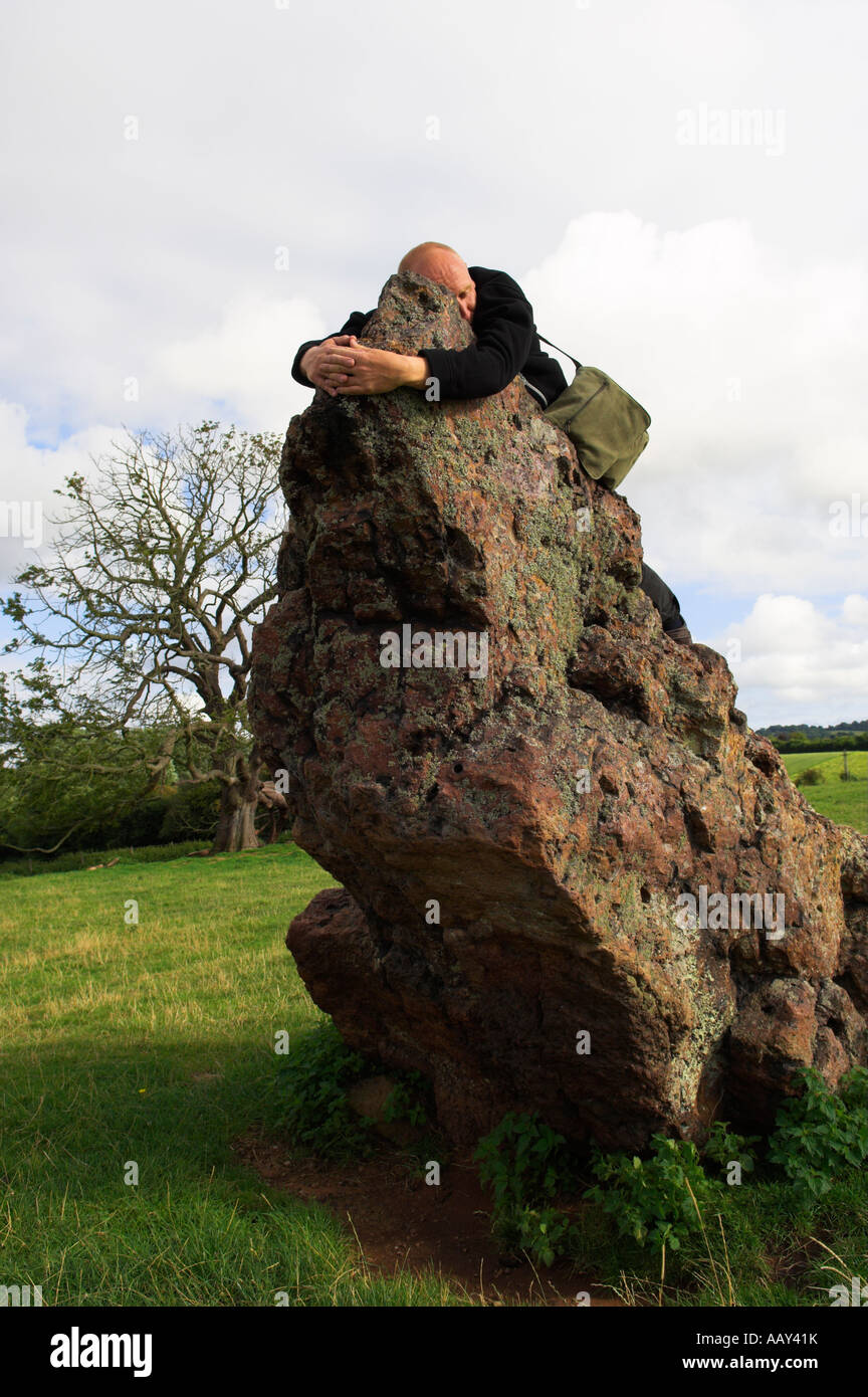 Man hugging stone Stanton Drew stone circle Somerset England Stock ...