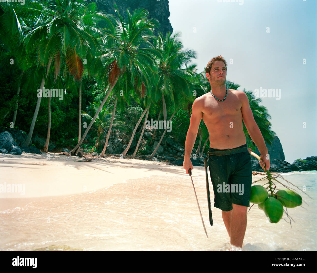 cool man walking on tropical beach with coconuts Stock Photo - Alamy