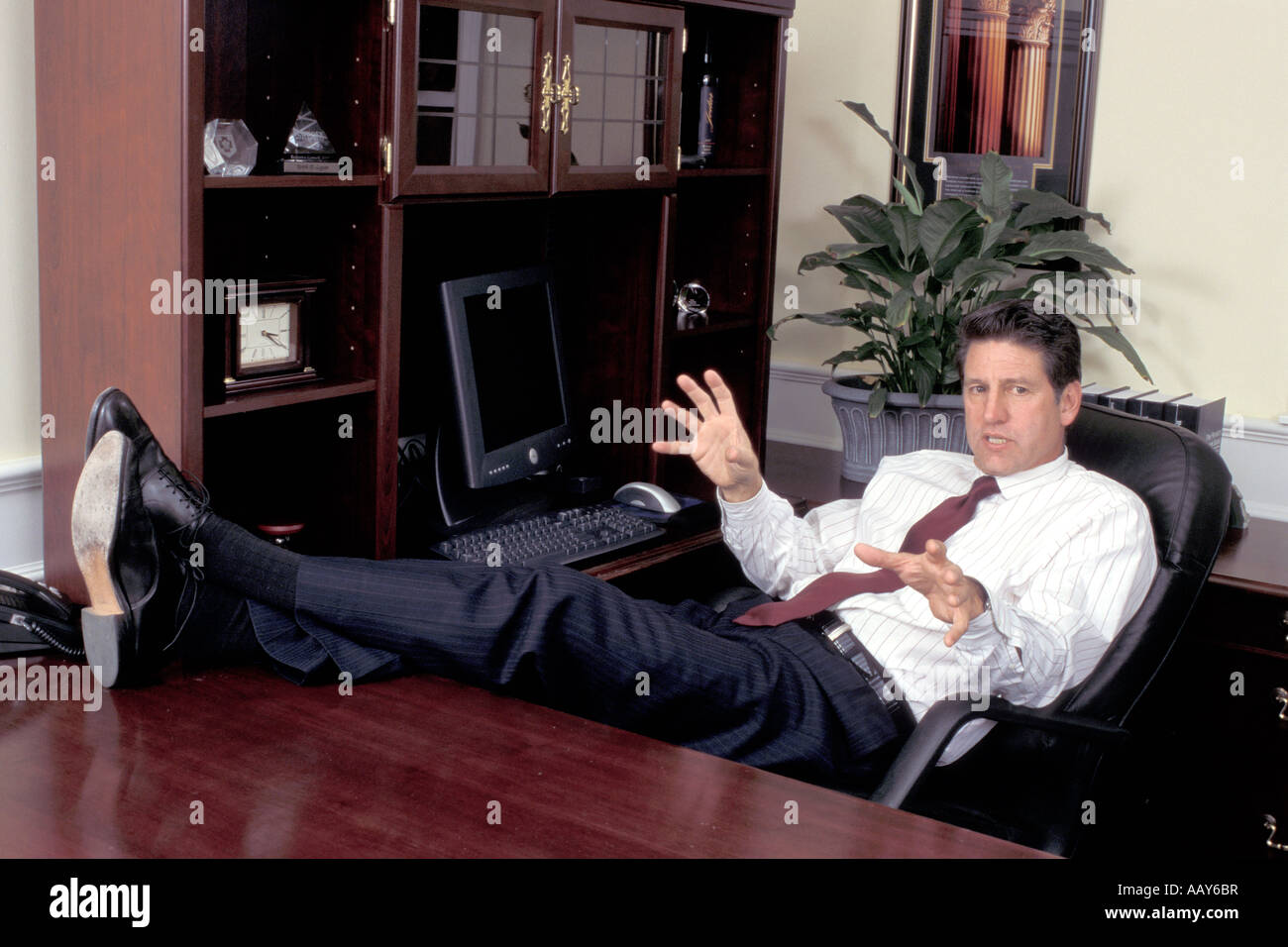 businessman with feet up on desk talking and expressing ideas about ...