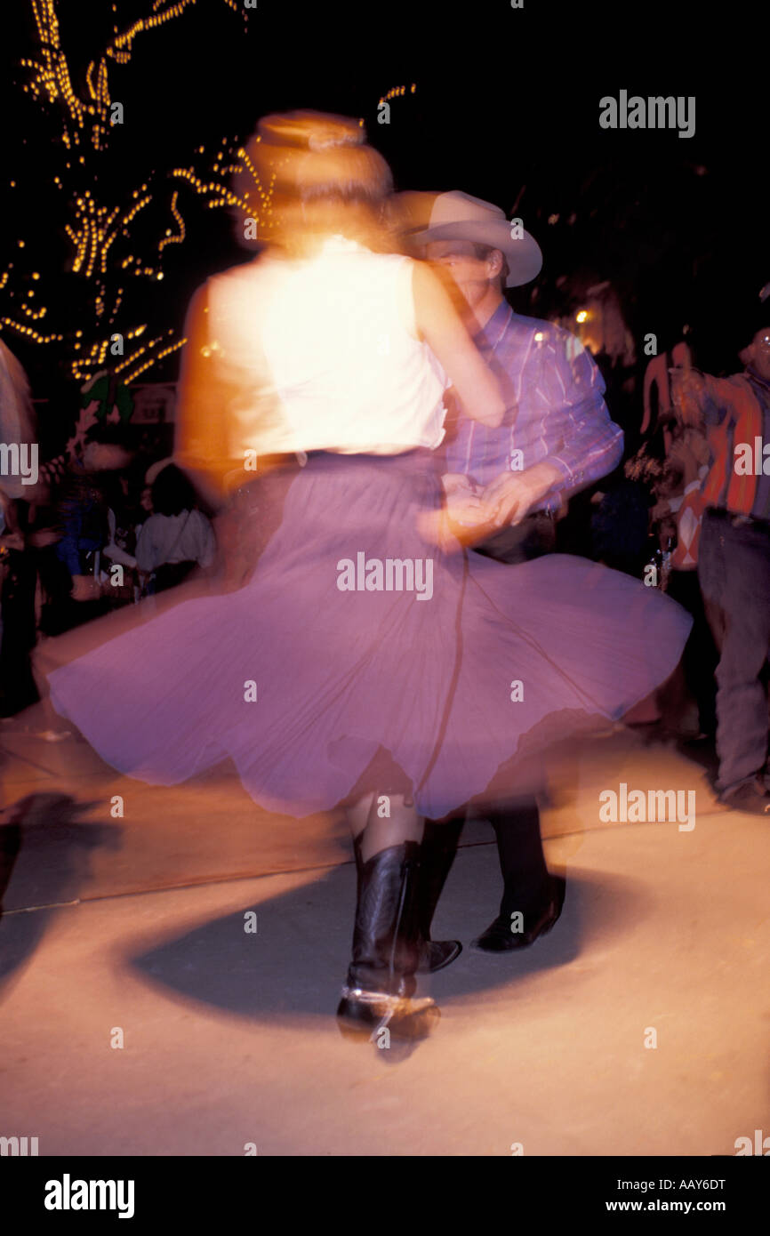 cowboy and cowgirl dancing a western dance at a party spinning in ...