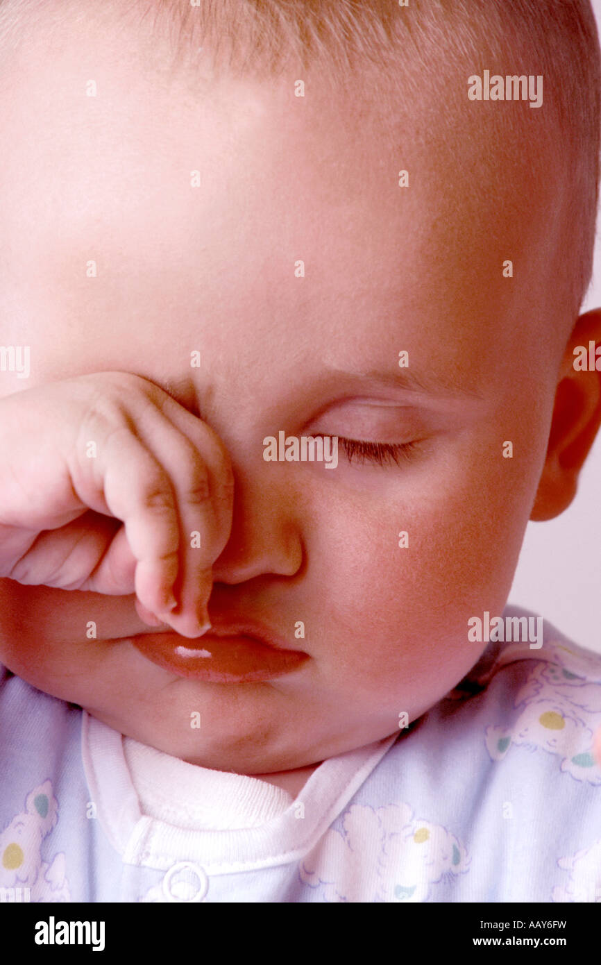 sleepy baby infant face rubbing eyes with hand ready to sleep facial ...