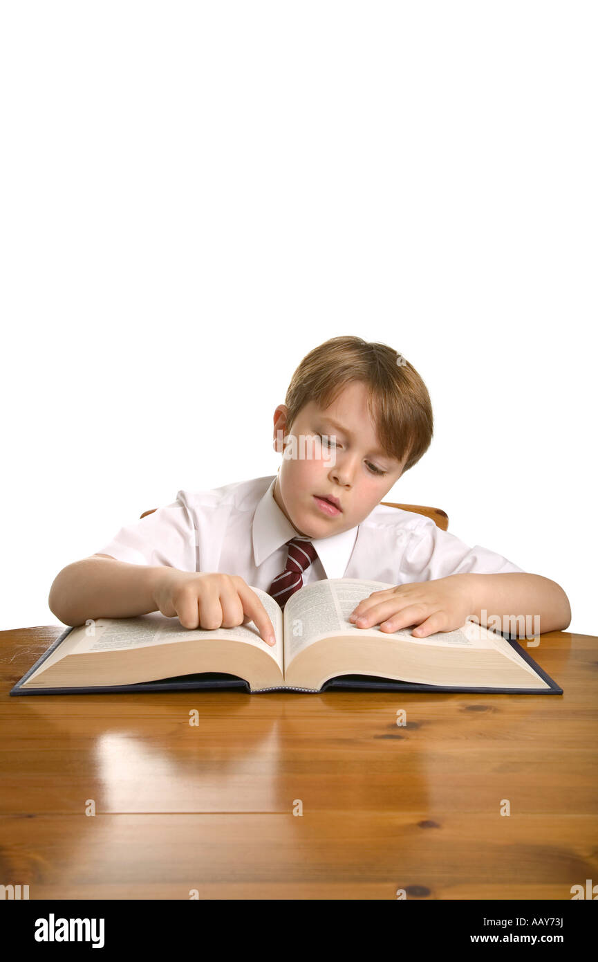 Education shot of a schoolboy reading from an encyclopedia whilst sat ...
