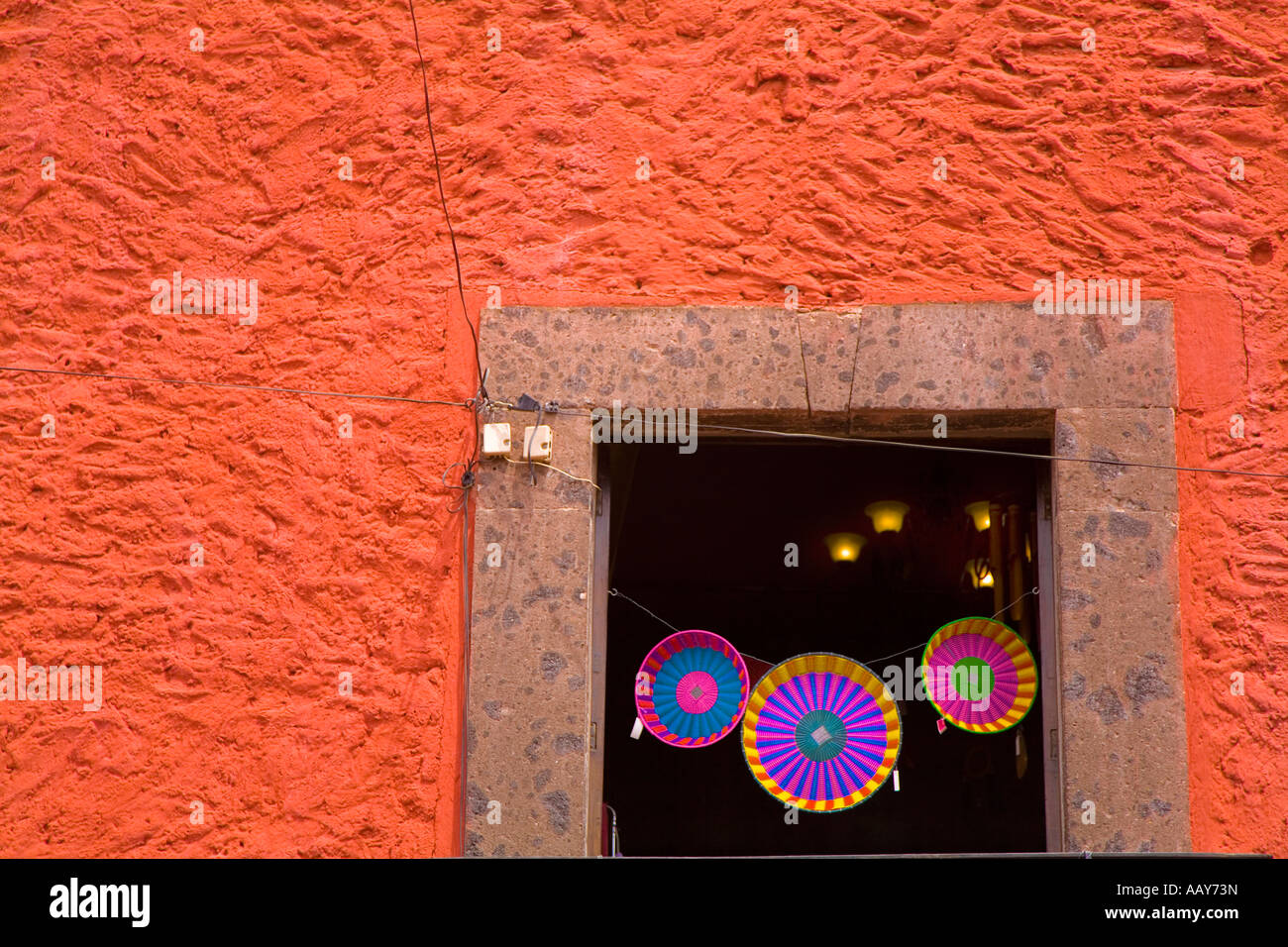 colorful handwoven baskets, mexican art, hanging in doorway, red wall ...
