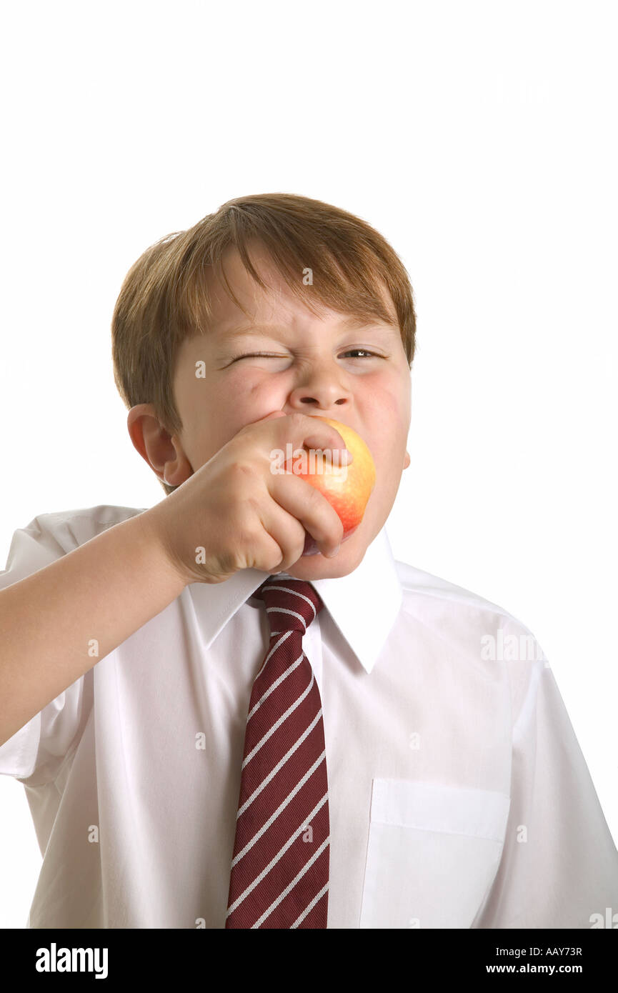 Education shot of a Boy in school uniform taking a big bite from an ...