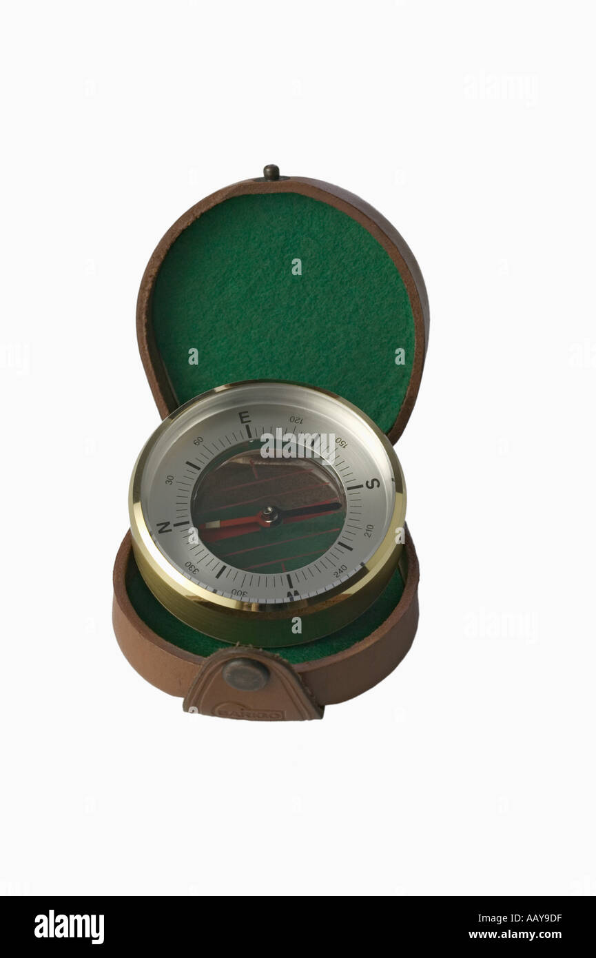 Still life of a compass in leather case silhouetted on white background ...