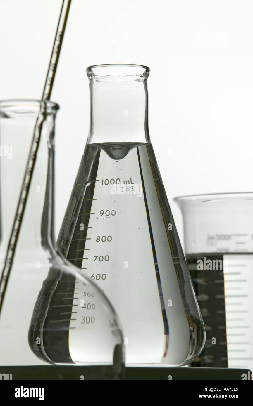 Chemical beakers flasks and other glassware still life on a white ...