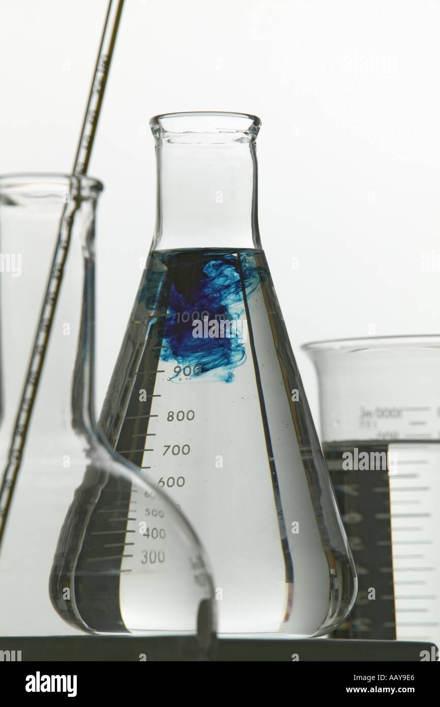 Chemical beakers flasks and other glassware still life on a white ...