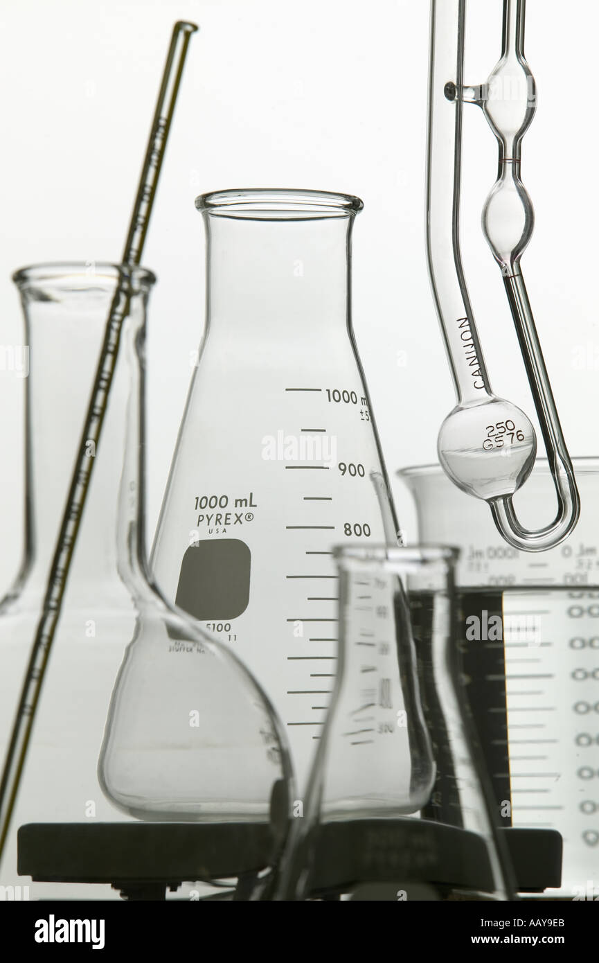 Chemical beakers flasks and other glassware still life on a white ...
