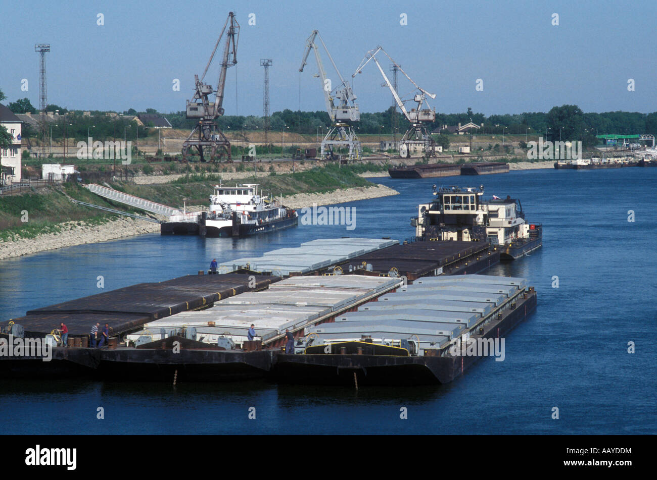 Five barges and a tugboat at a loading area on the Danube at Sturovo ...