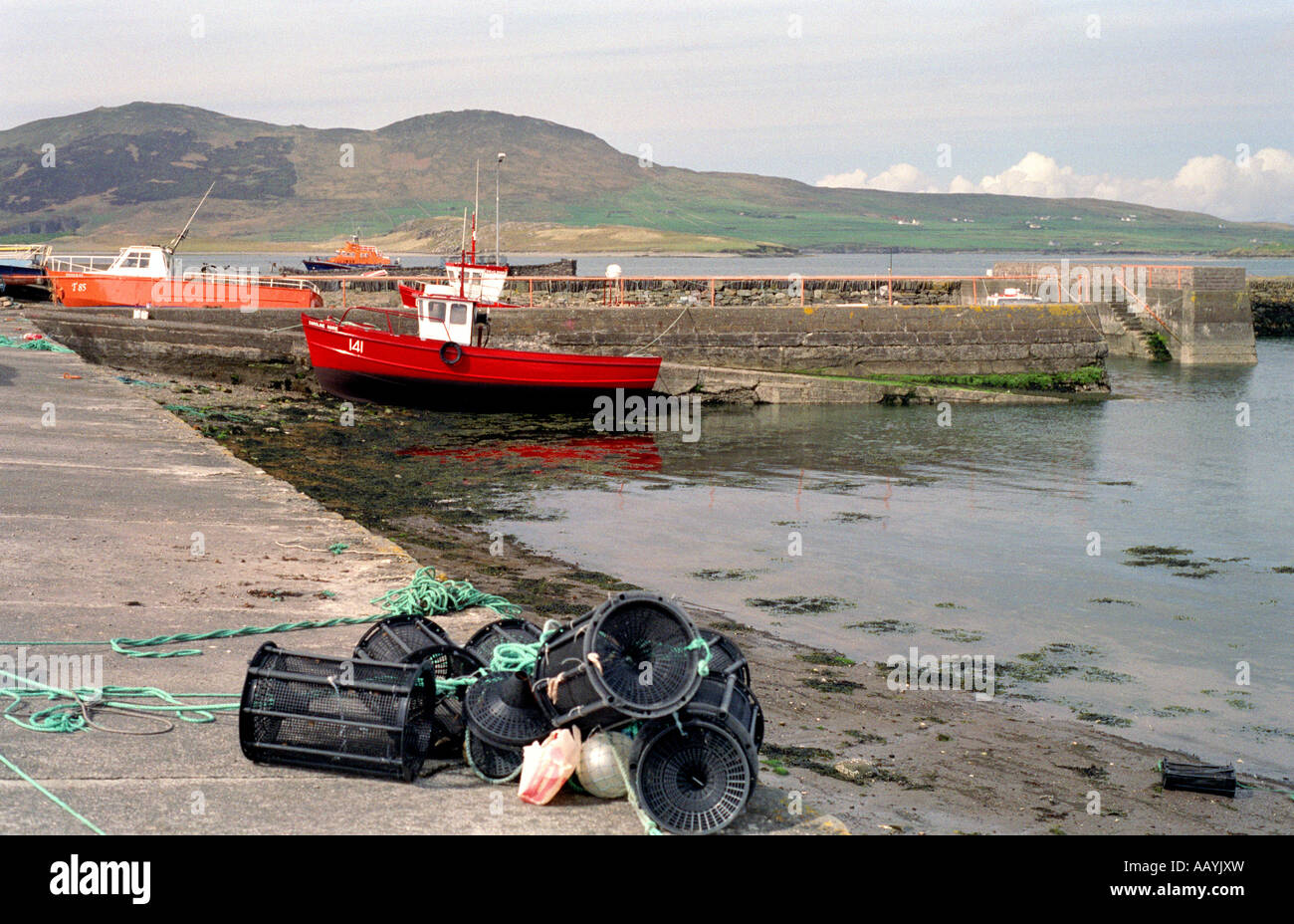 Harbour wall and boats await high tide on Valencia Island, County Kerry ...