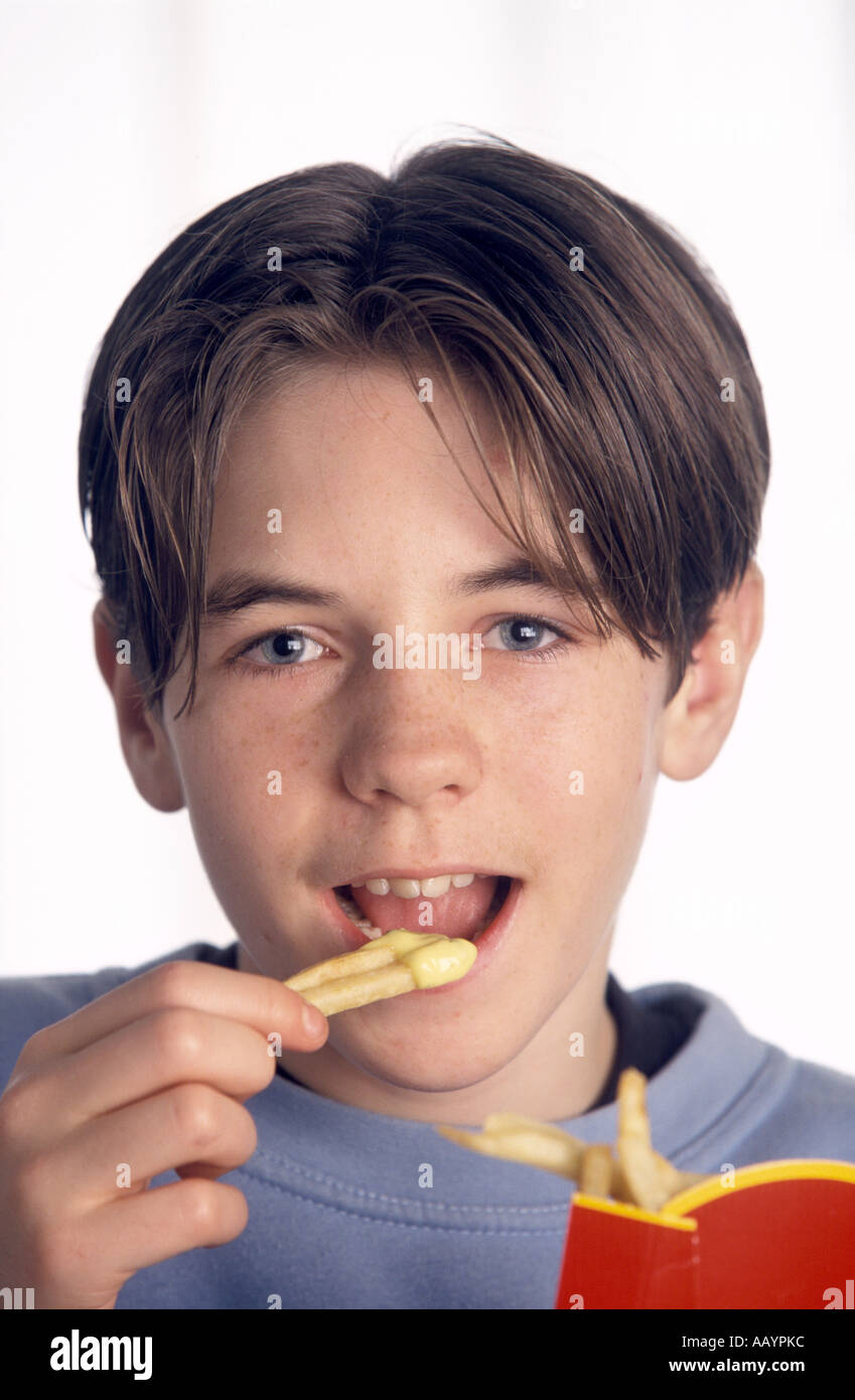 Teenage boy eating French fries Stock Photo - Alamy