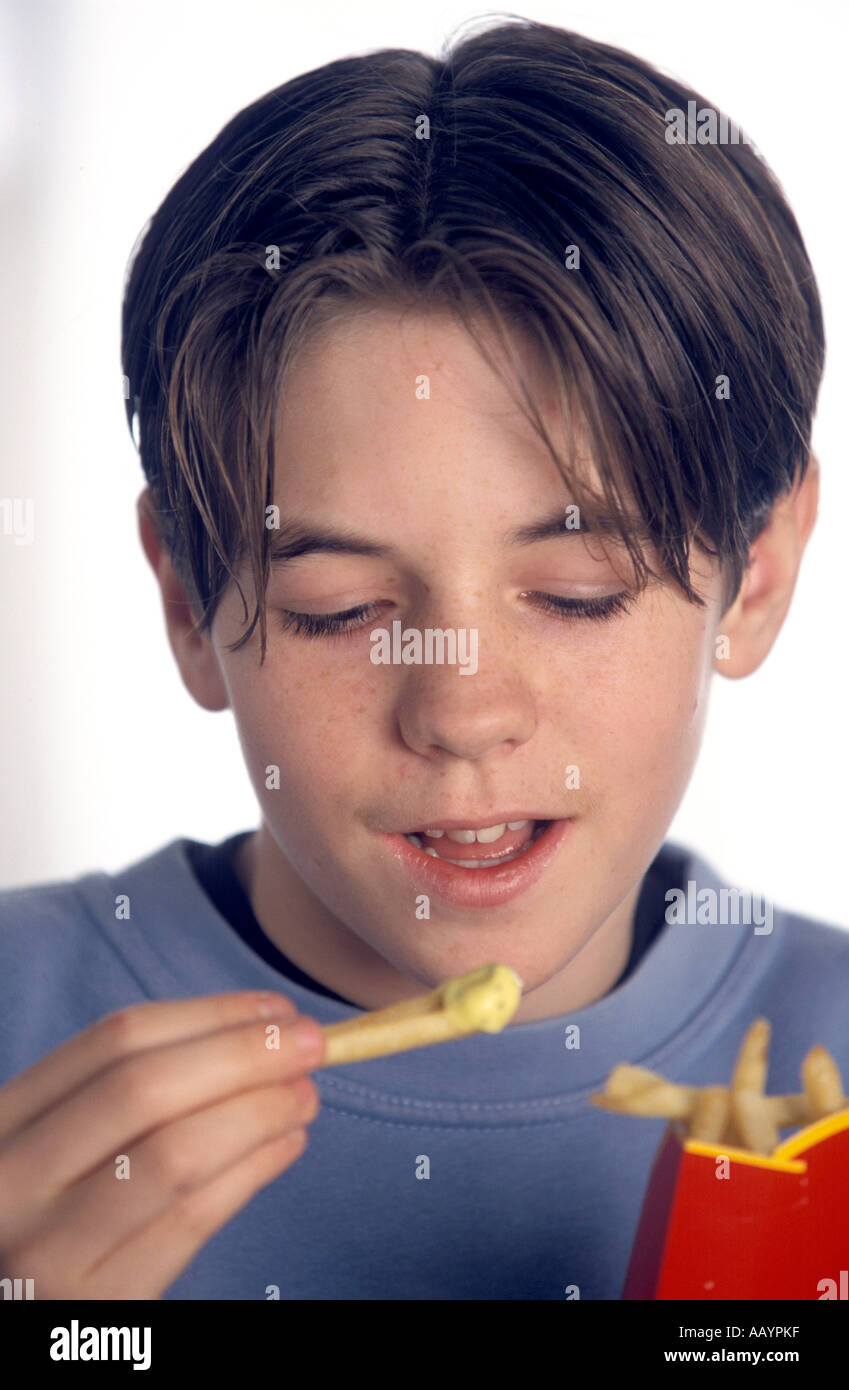 Teenage boy eating French fries Stock Photo - Alamy