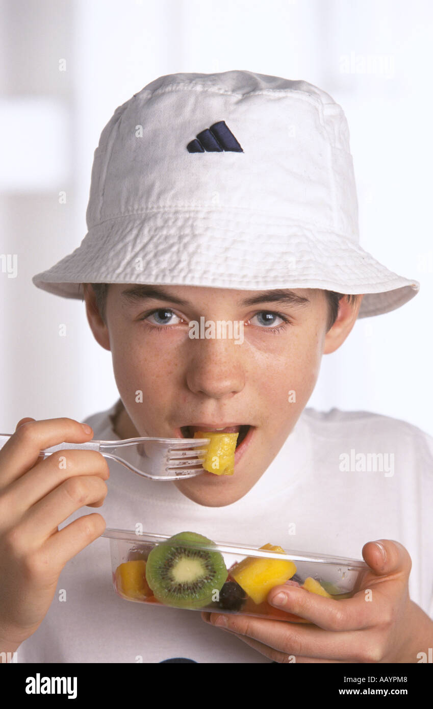 Teenage boy eating fruit salad Stock Photo - Alamy