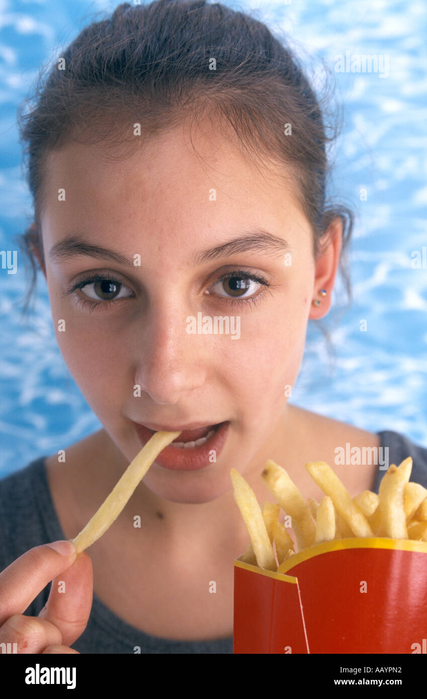 Teenage girl eating French fries Stock Photo - Alamy