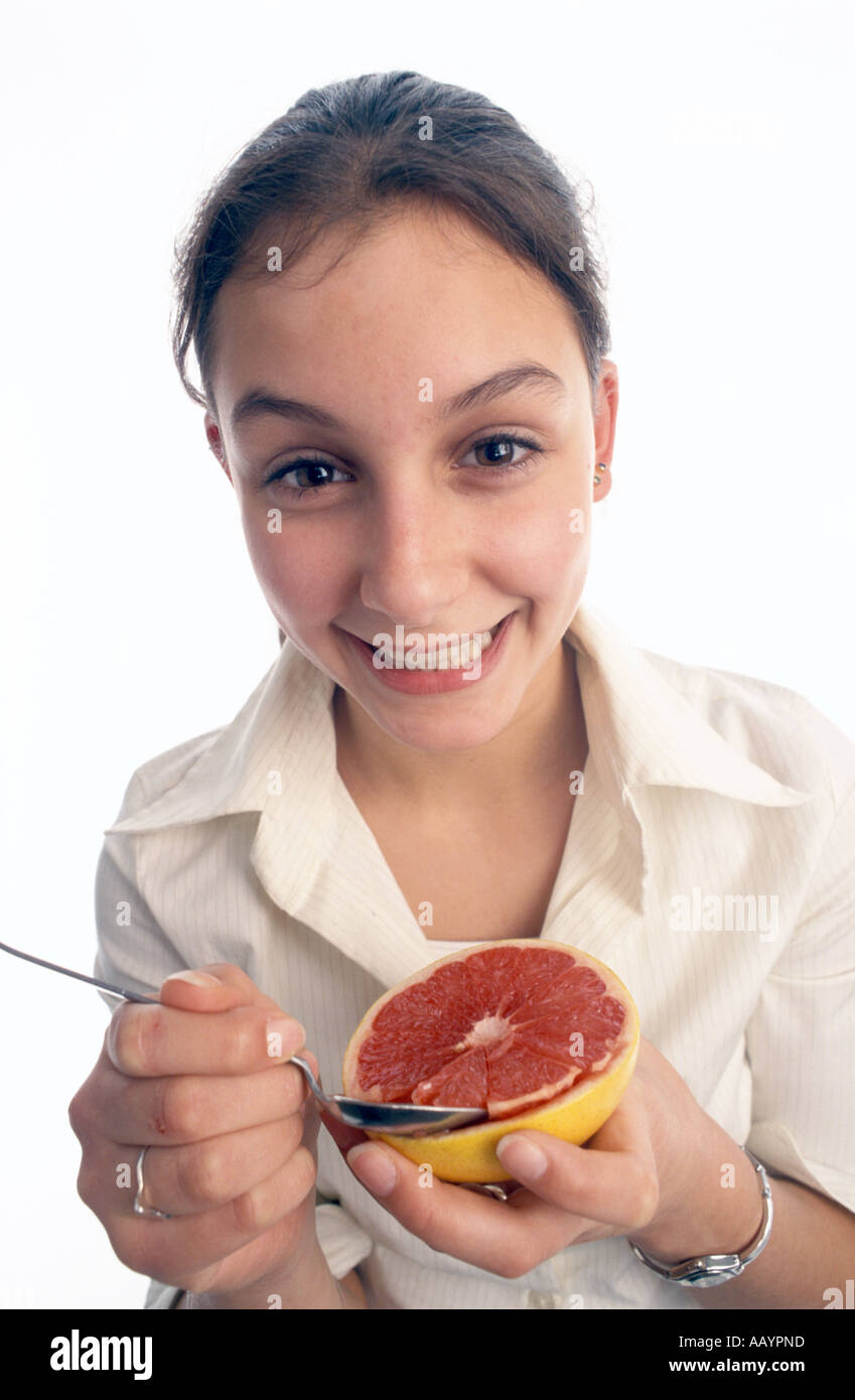 Teenage girl eating grapefruit Stock Photo - Alamy