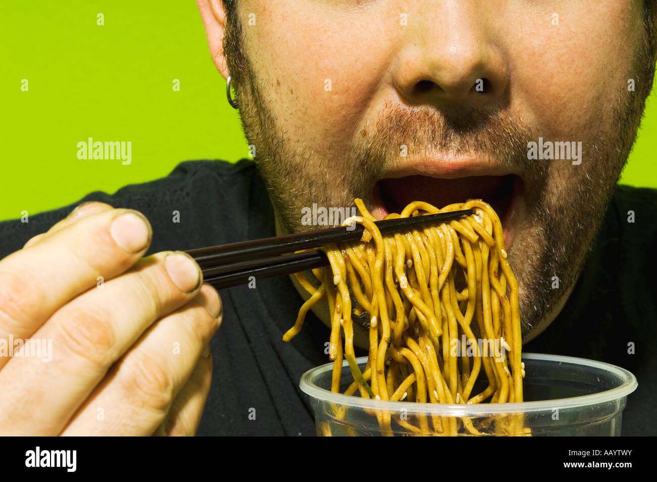 Man eating noodles with chopsticks Stock Photo - Alamy