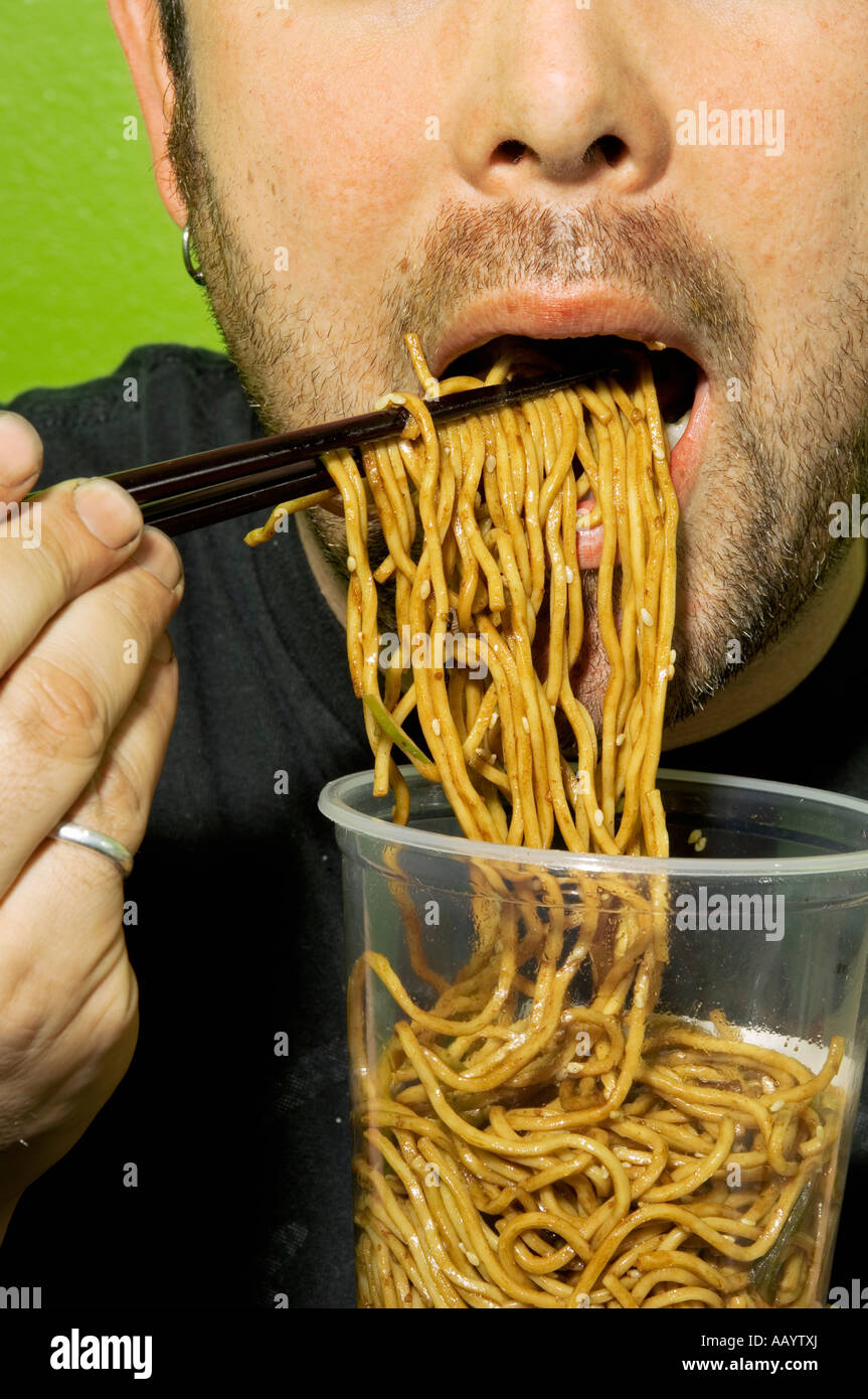 Man eating noodles with chopsticks Stock Photo - Alamy