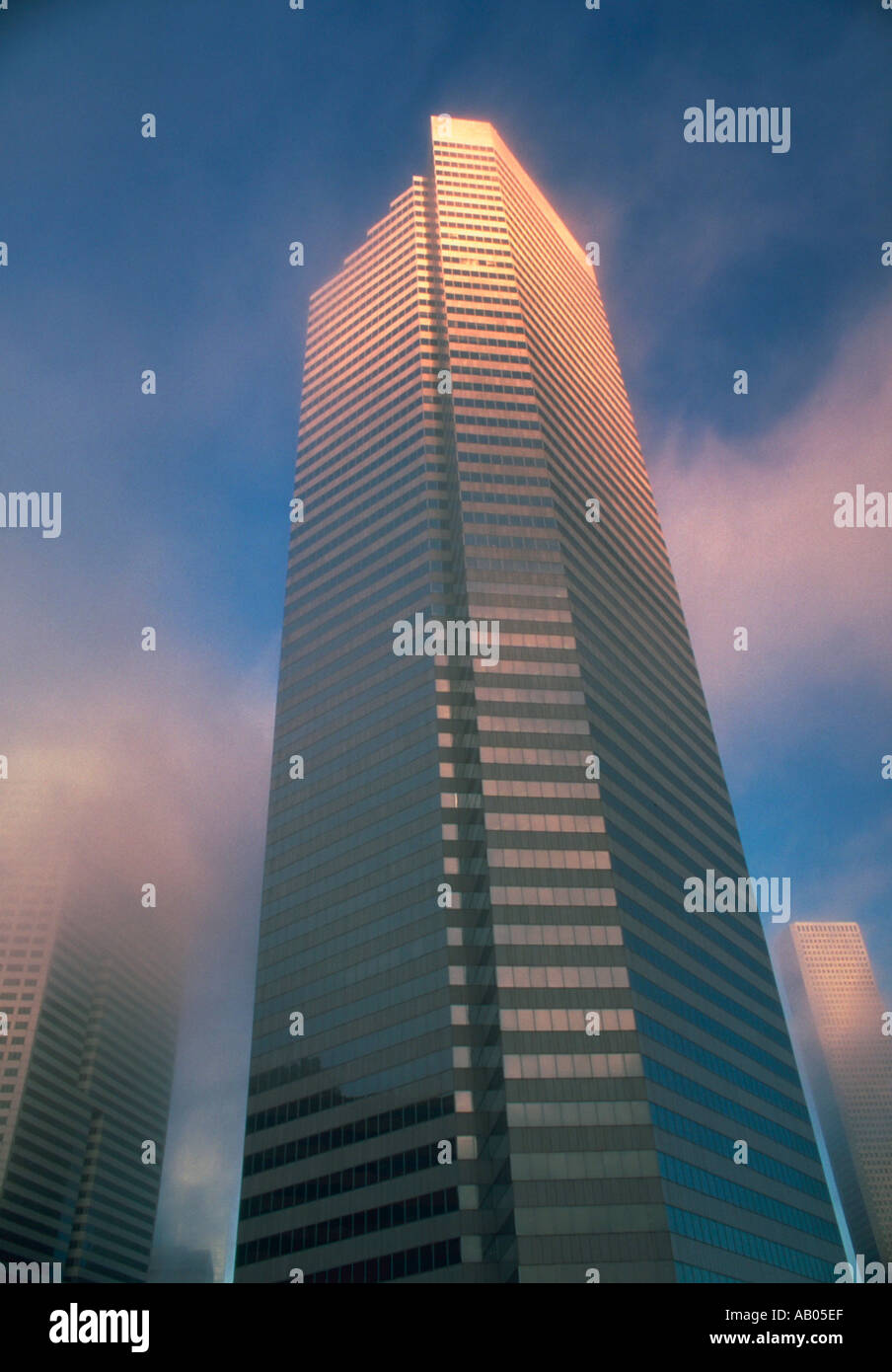 The Chevron Tower rises up through he clouds toward blue sky in Houston ...