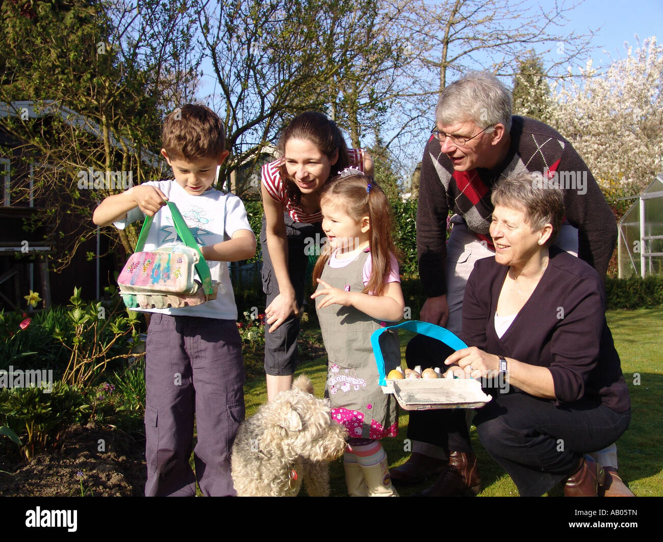 A family searching for easter eggs in the garden Stock Photo - Alamy