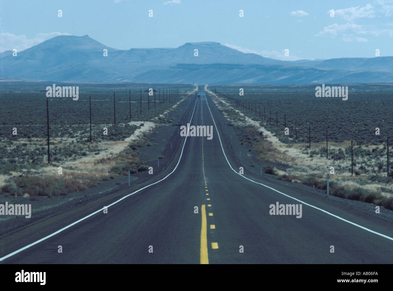 A straight two lane highway crosses the desolate Nevada countryside A ...