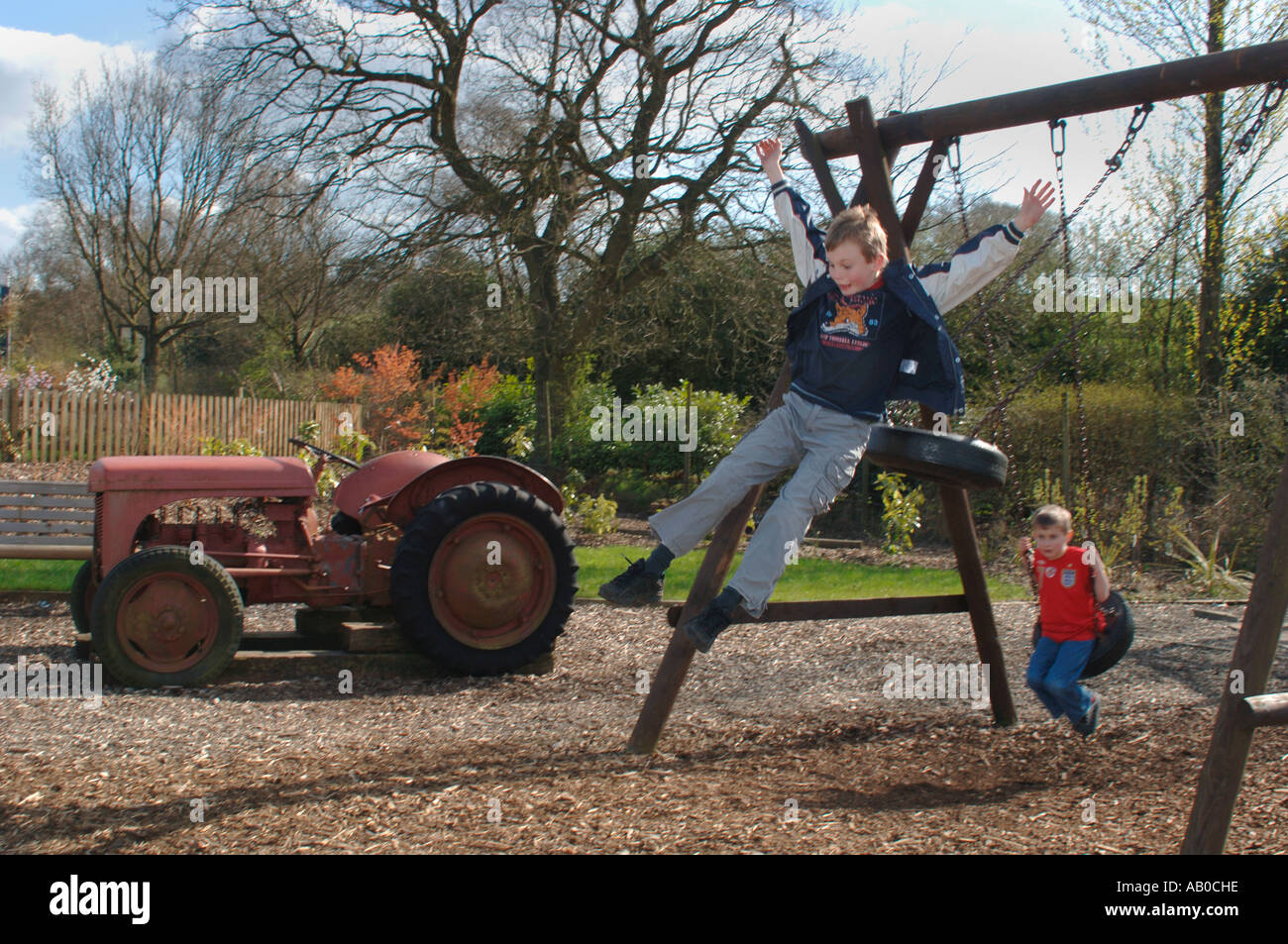 Boy Jumping Off A Swing Stock Photo - Alamy