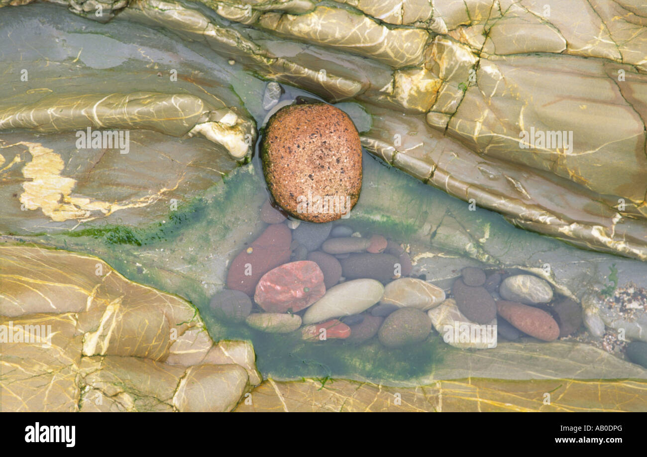 Coast sea a small pool of sea water amoungest the rocks with pebbles ...