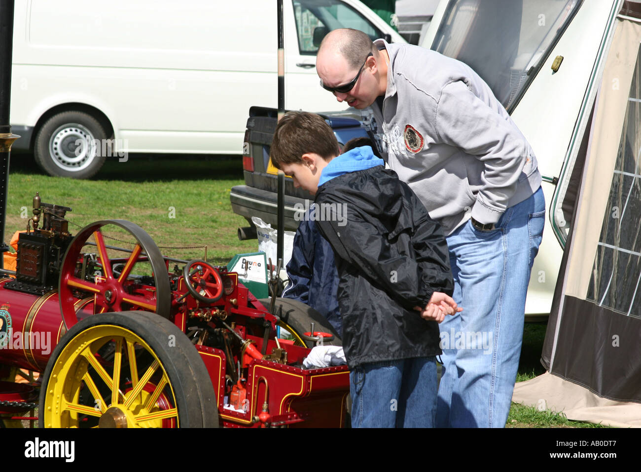 Man and boy inspecting the controls of a scale model steam traction ...