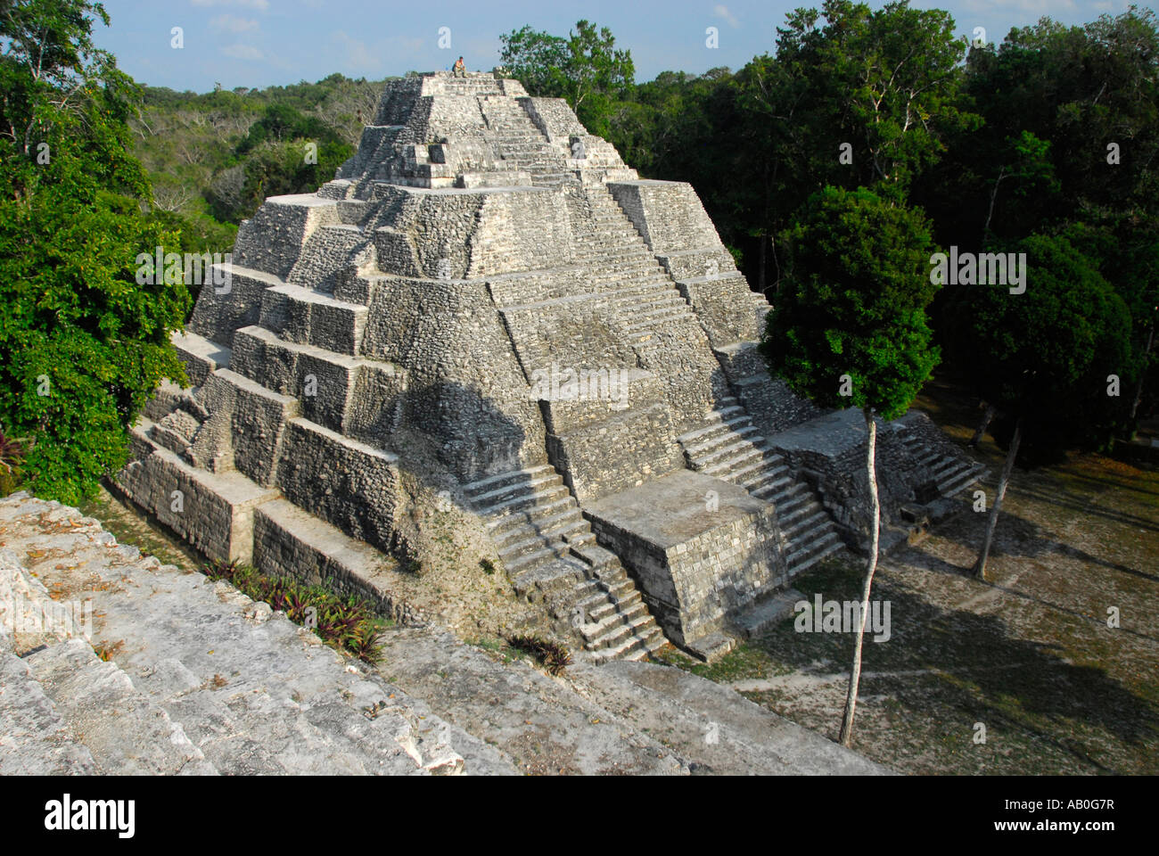 Young man on top of pyramid in Yaxha Ruins site, Peten, Guatemala ...