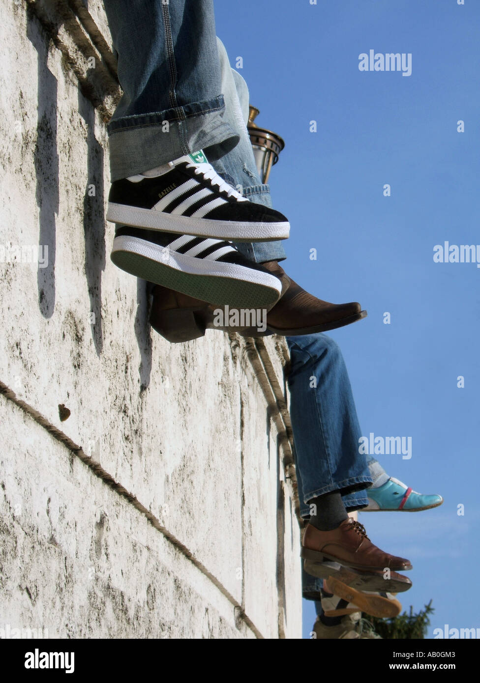 close up of people's feet sitting on wall in rome Stock Photo - Alamy