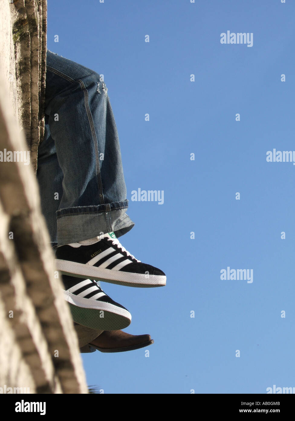 close up of people's feet sitting on wall in rome Stock Photo - Alamy