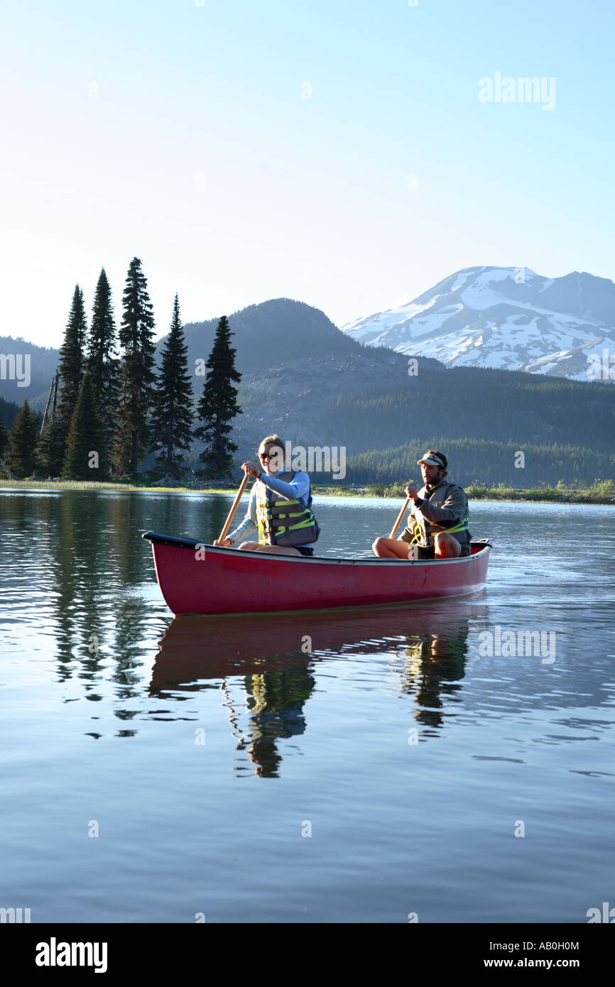 Couple paddling canoe on lake Stock Photo - Alamy