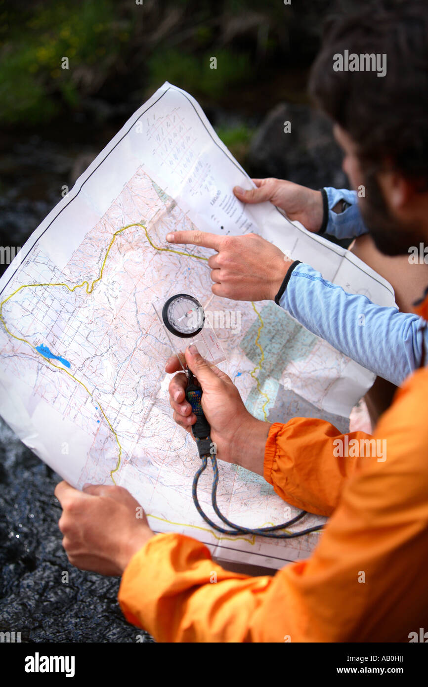 Hikers looking at map and compass Stock Photo - Alamy